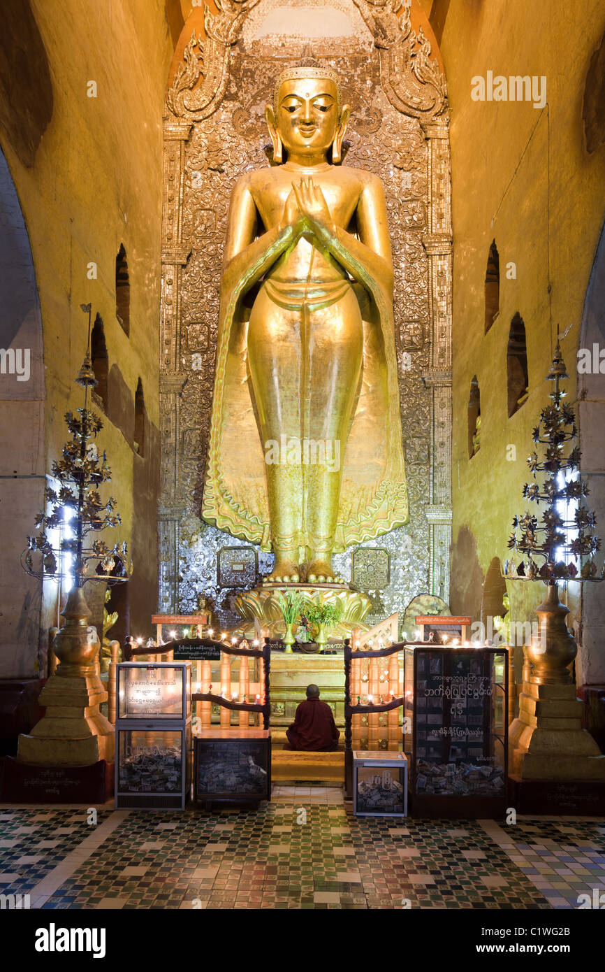 Gold Buddha statue with praying monk in Ananda temple, Bagan, Burma ...