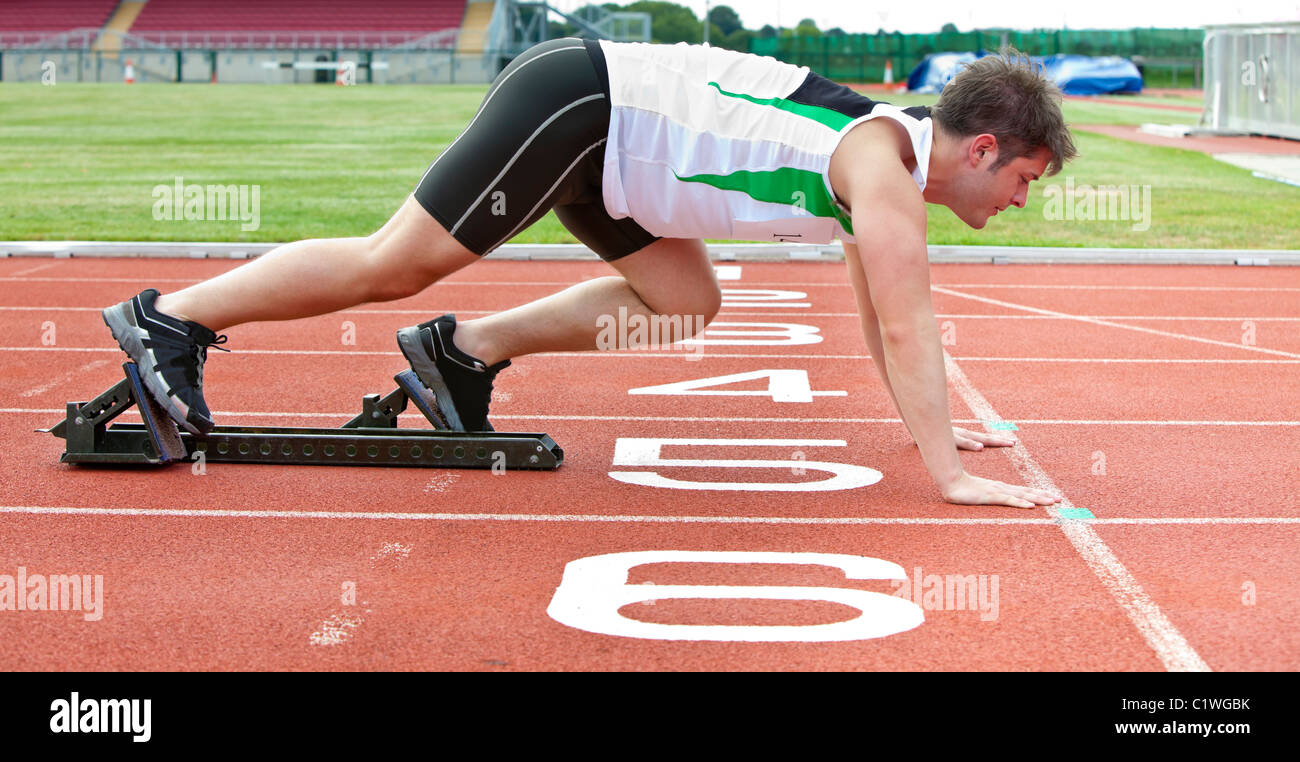 Handsome sprinter on the starting line putting his foot in the s Stock ...