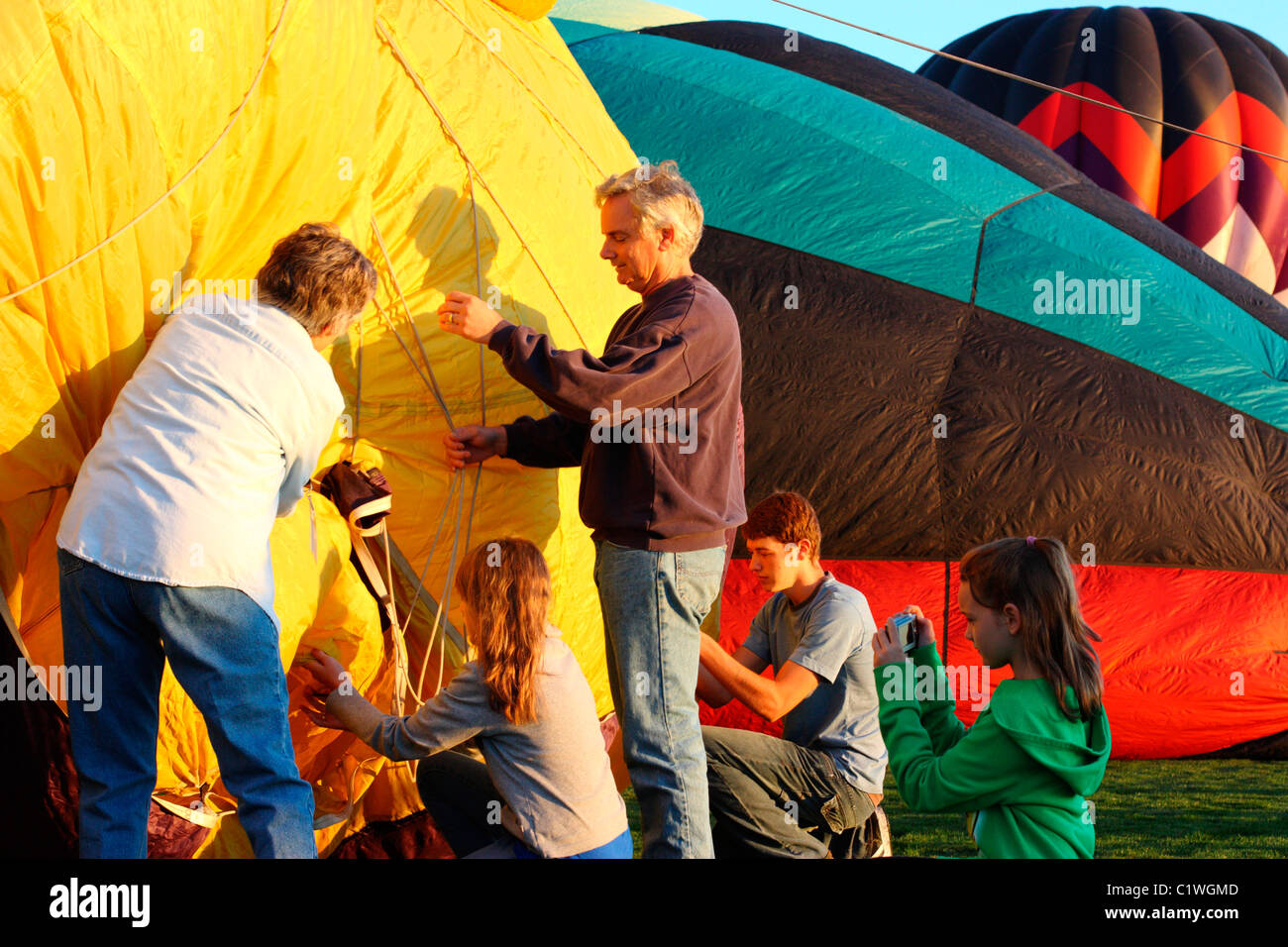 USA, California, Ripon, Crew members adjusting hot air balloon at Color ...