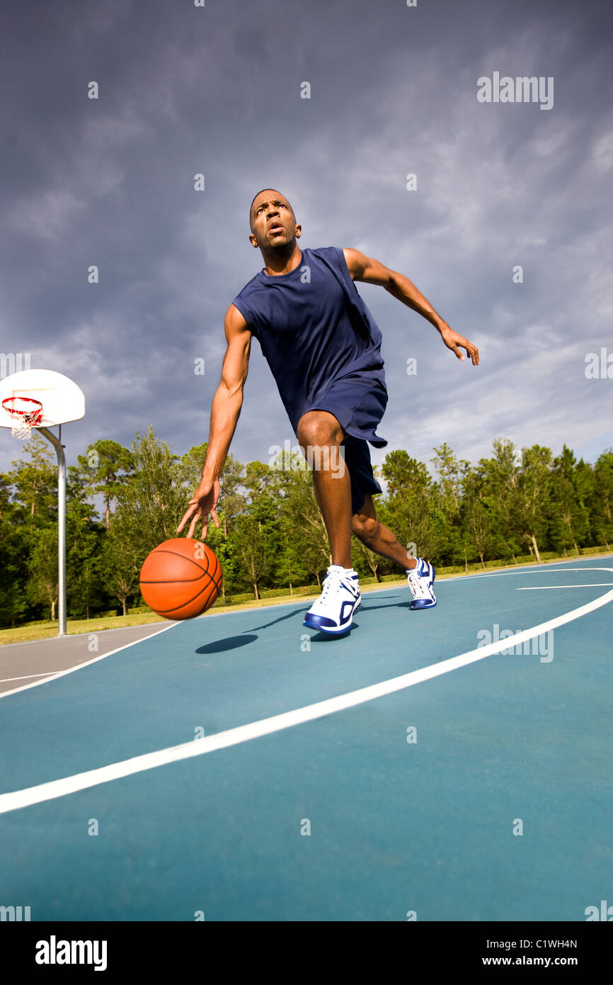 Young man bouncing basketball hi-res stock photography and images - Alamy