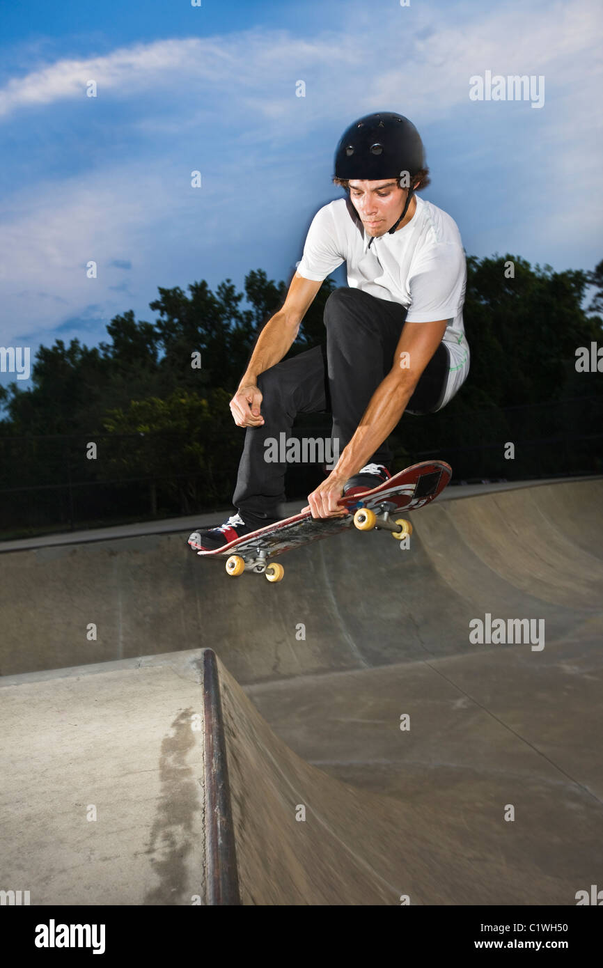 Male skateboarder jumping from ramp at skateboard park Stock Photo - Alamy