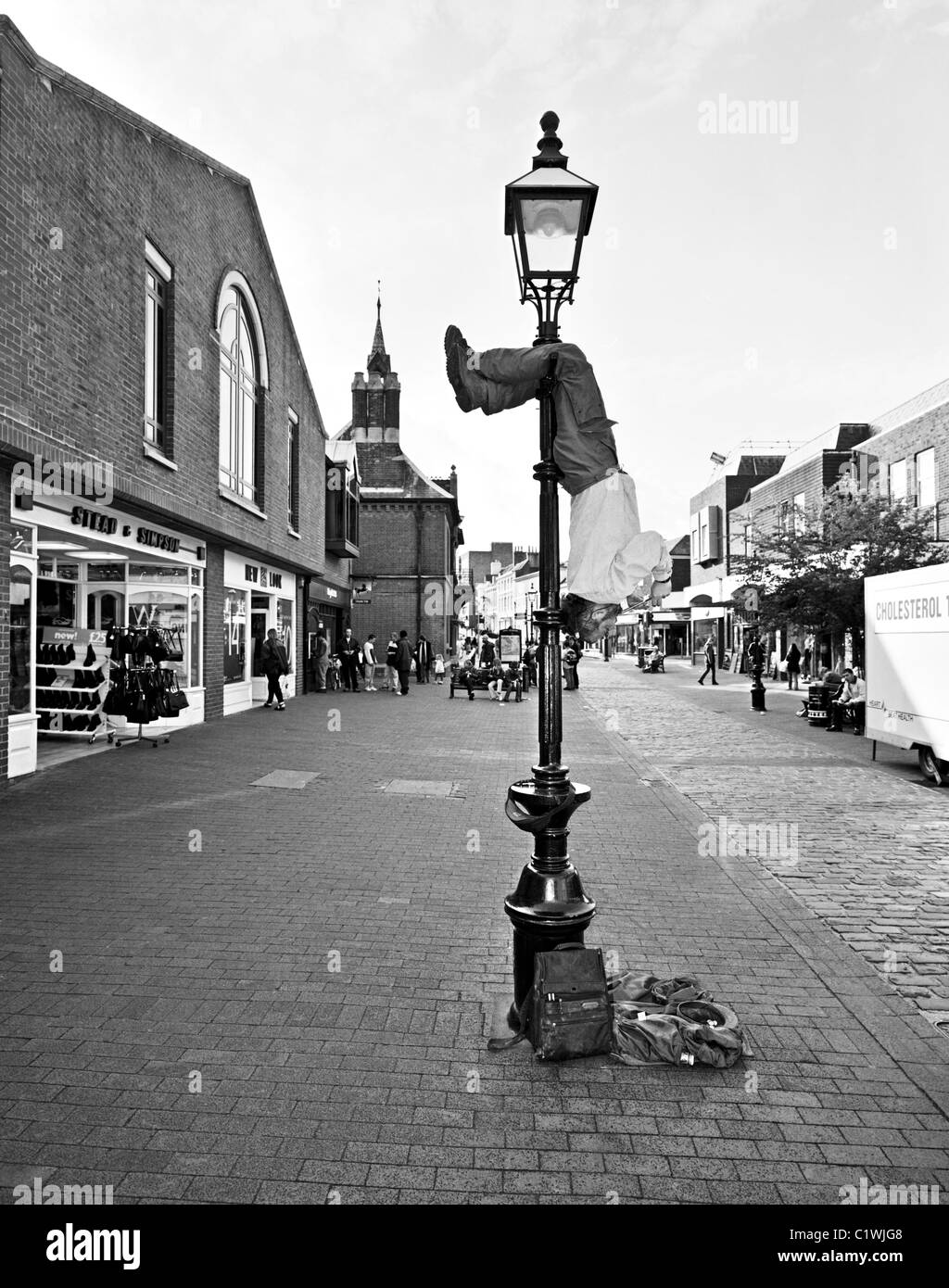 Street Entertainer Playing a Flute Whilst Hanging From a Lamp Post ...