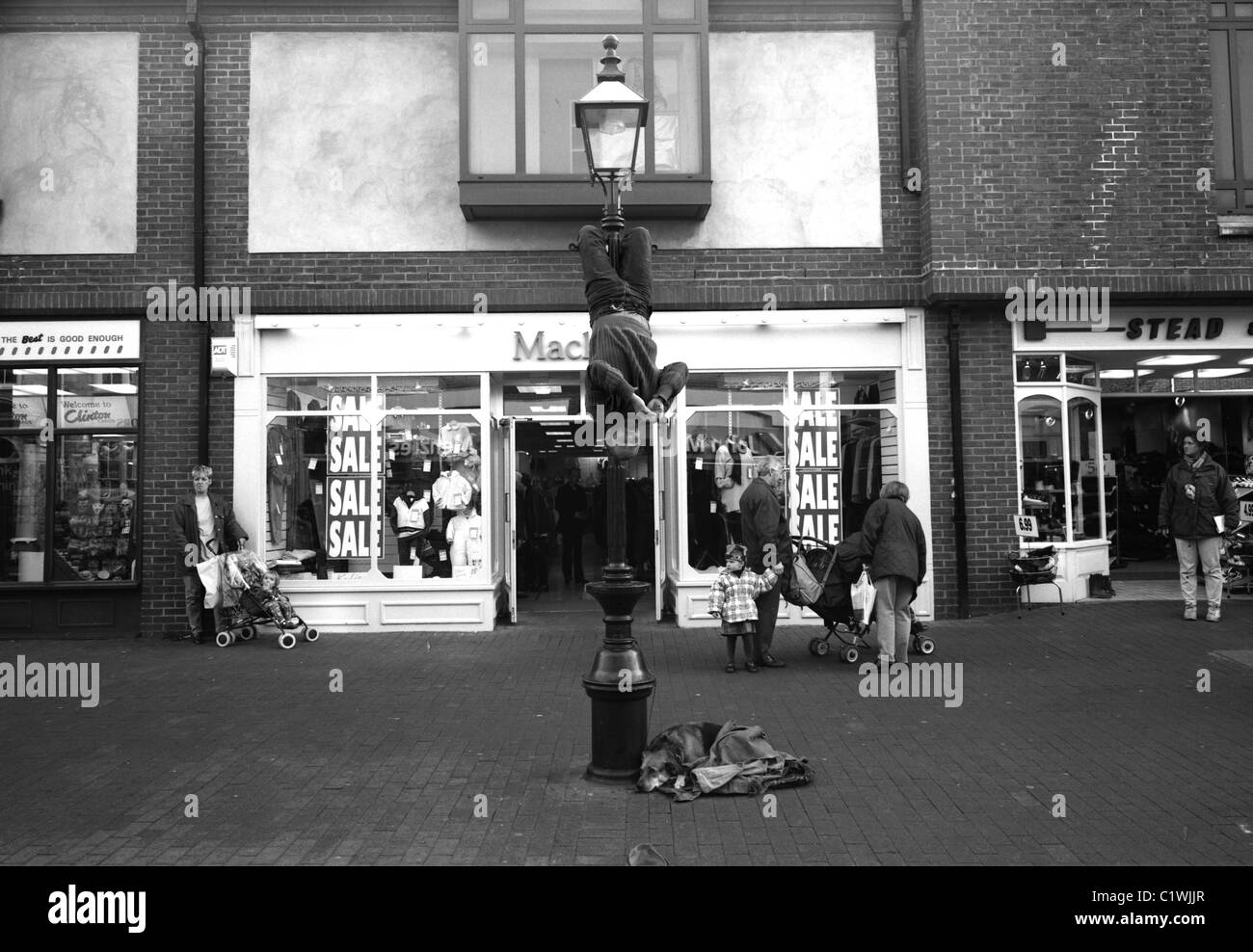 Street Entertainer Playing a Flute Whilst Hanging From a Lamp Post ...