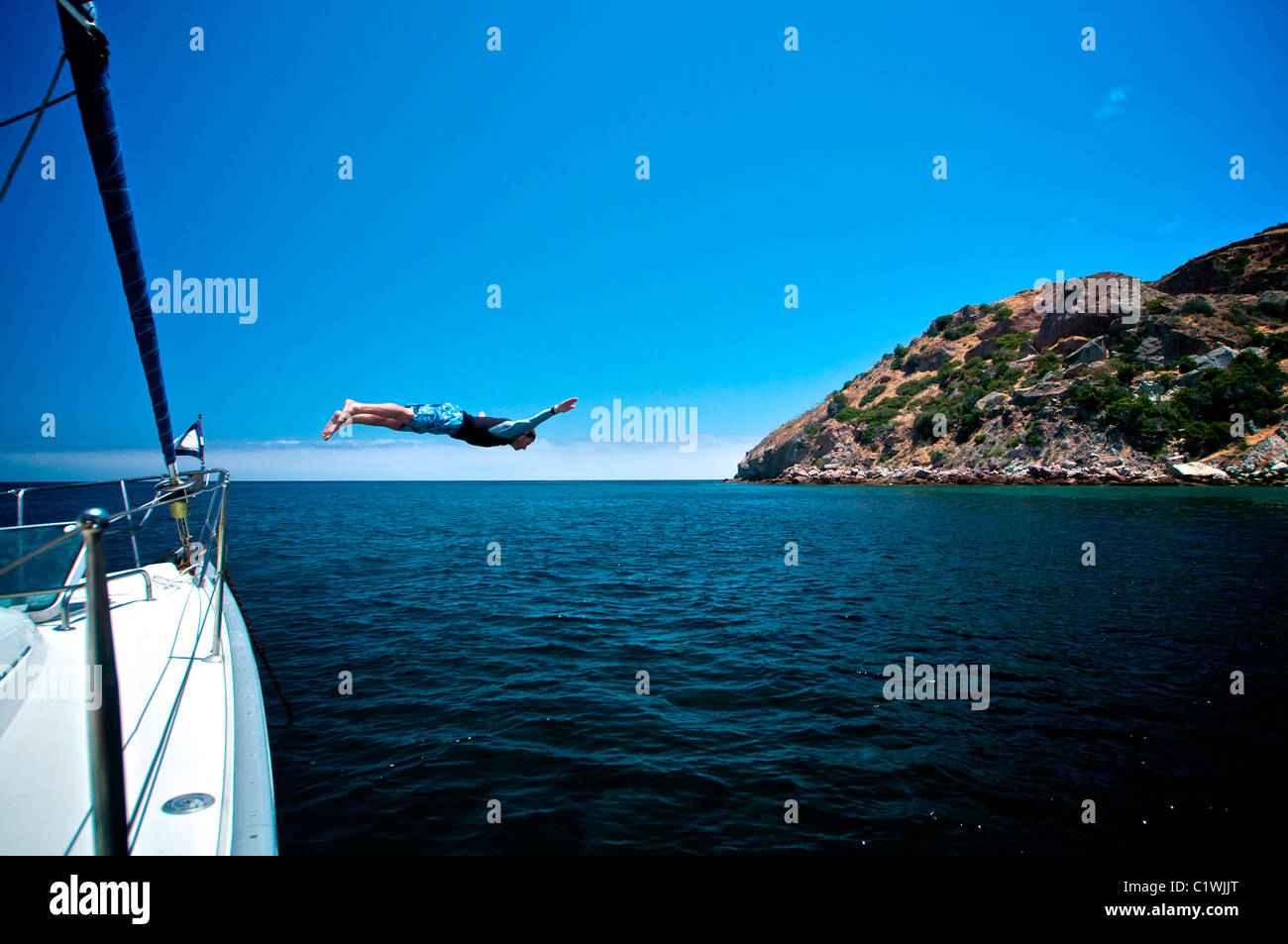 Man diving off a sailboat in the ocean, Catalina Island, California ...