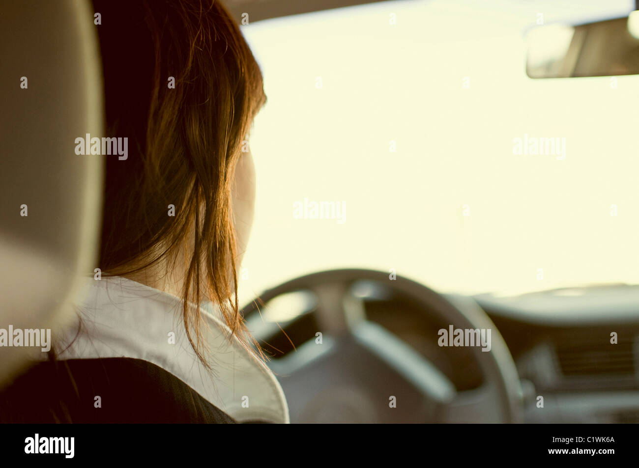 Rear view of a woman driving a car Stock Photo - Alamy