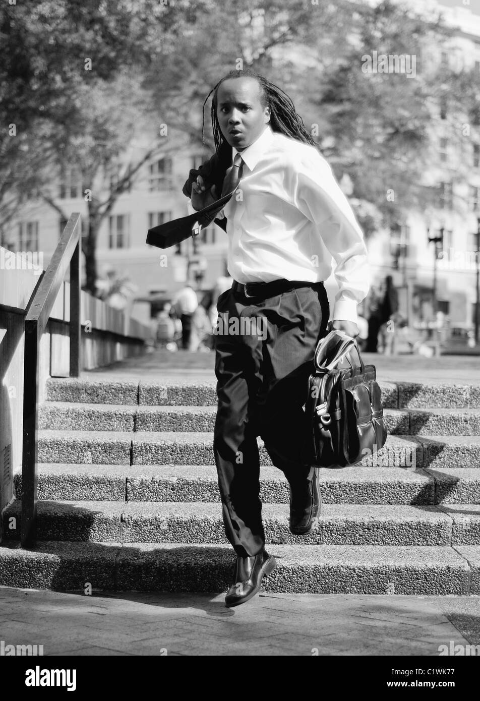 Businessman moving down steps Stock Photo - Alamy