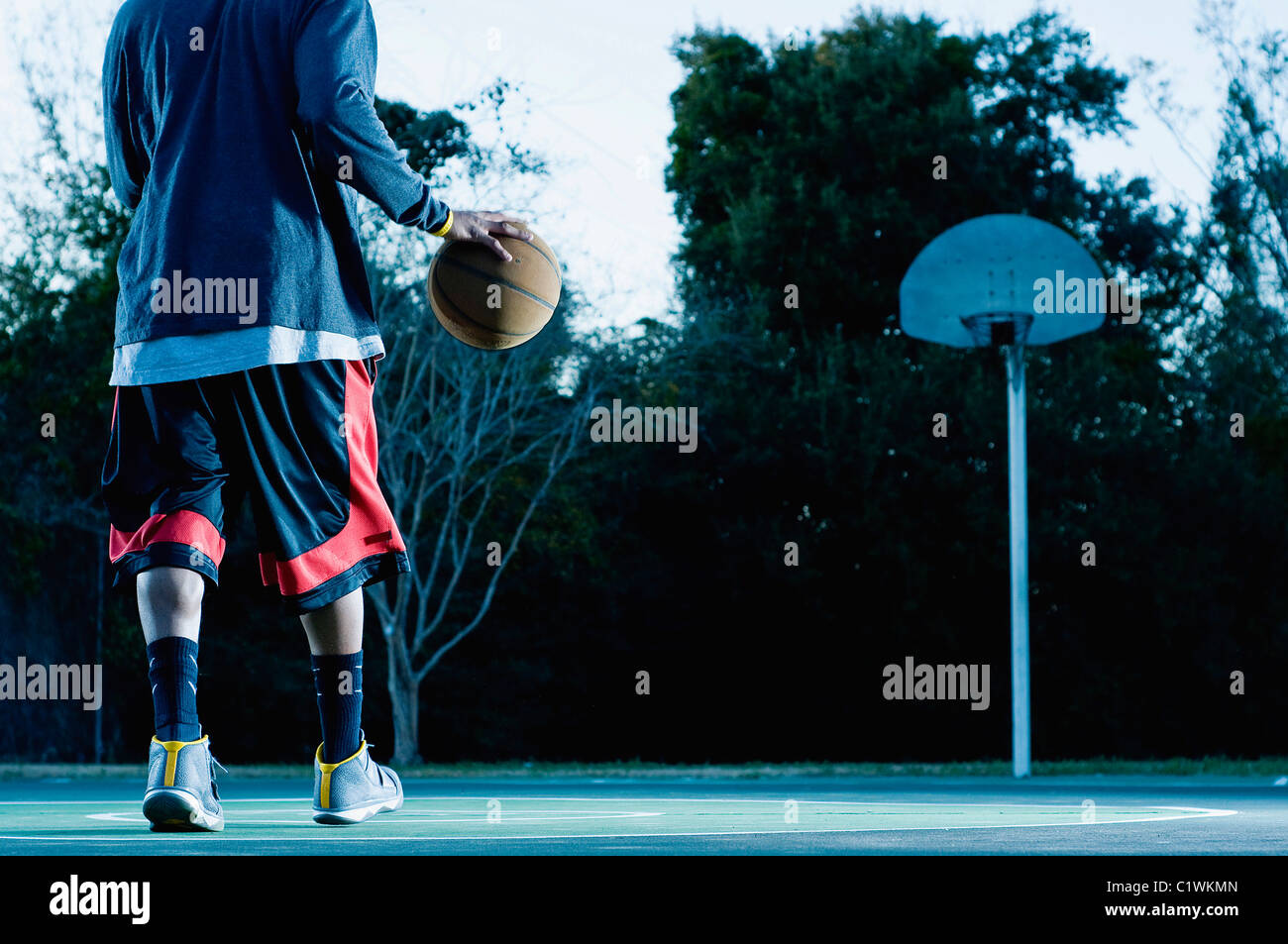 Basketball player practicing in a court Stock Photo - Alamy