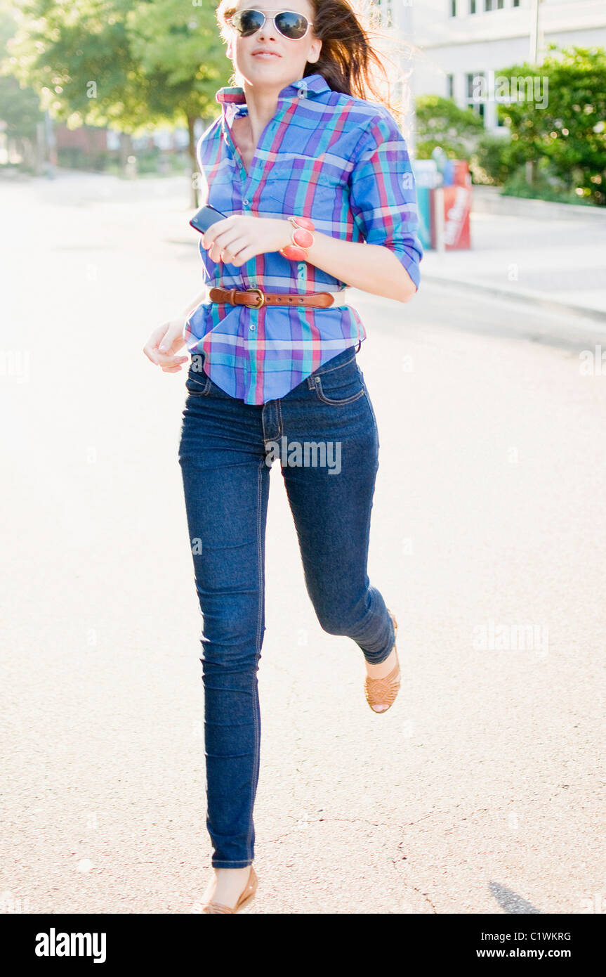 Woman running on a street Stock Photo - Alamy