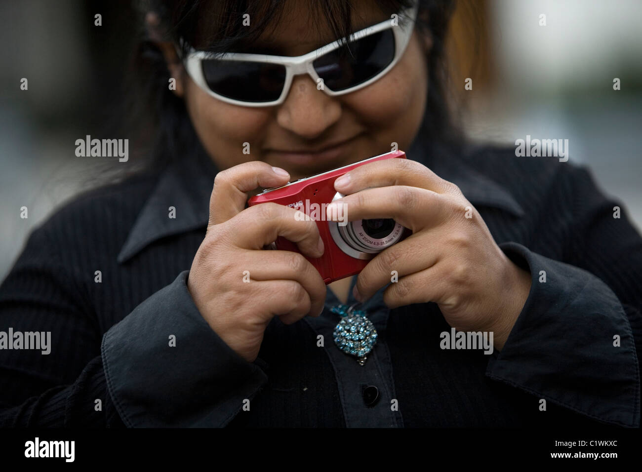 A blind female student touches a camera during a photography workshop ...