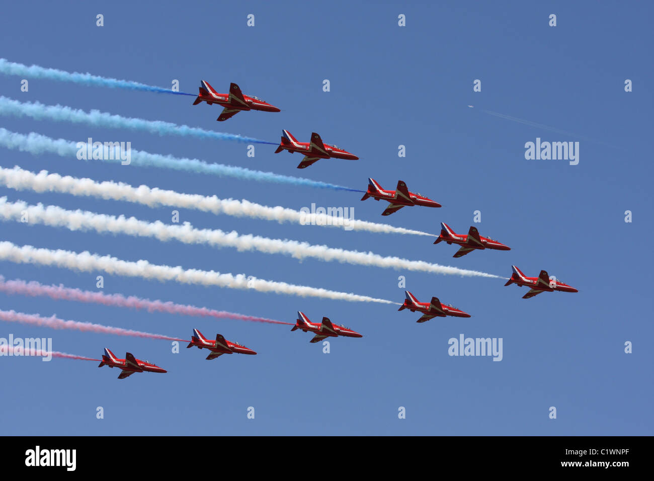 The red arrows flying in formation across a blue sky trailing smoke ...