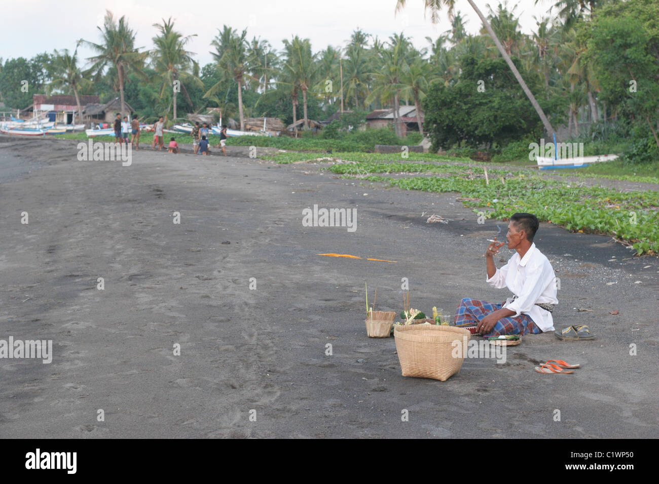 Balinese man sitting in the streets smoking a clove cigarette and ...