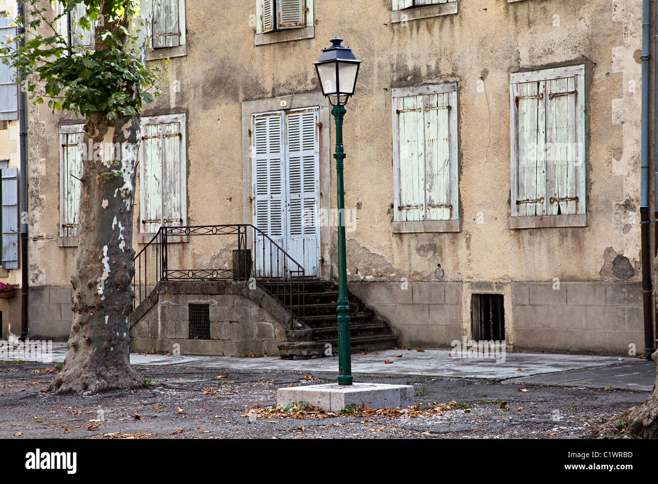 Faded shutters over windows and old street light Mas d'Azil department ...