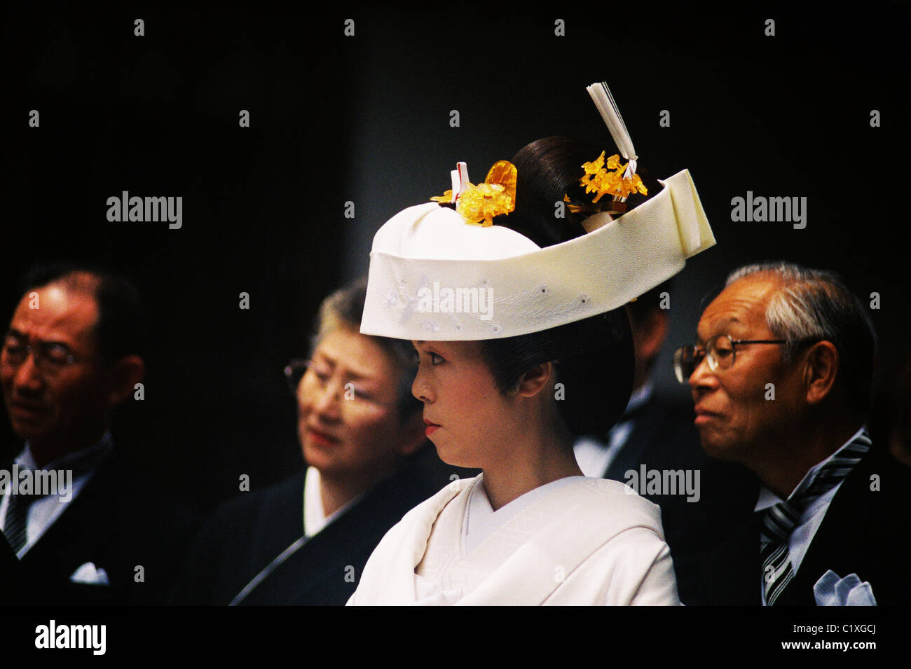 The bride wears a traditional head dress and white wedding kimono ...