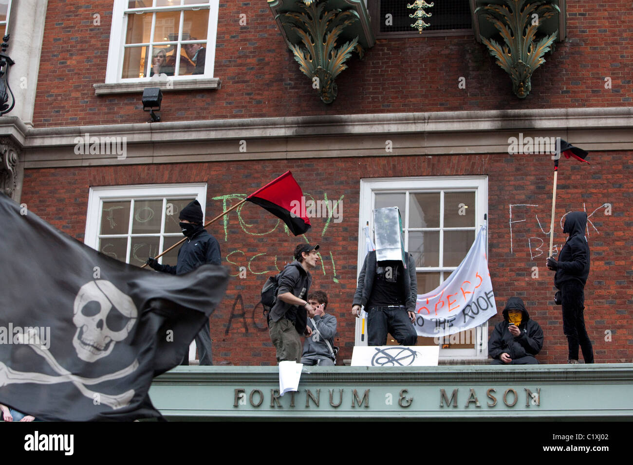 Anti-Cuts March in Central London, members of UK Uncut scale facade of ...