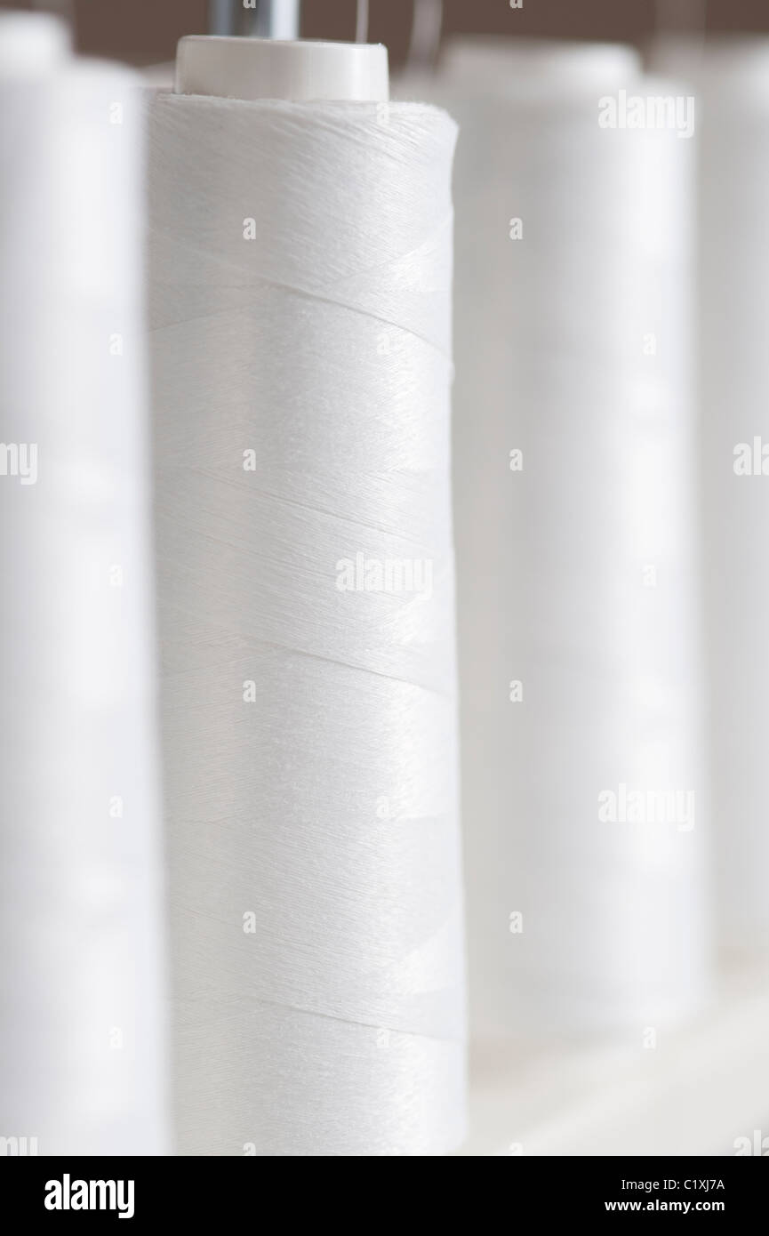 Serger with white thread spools Stock Photo - Alamy