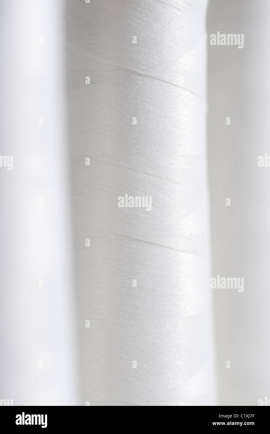 Serger with white thread spools Stock Photo - Alamy