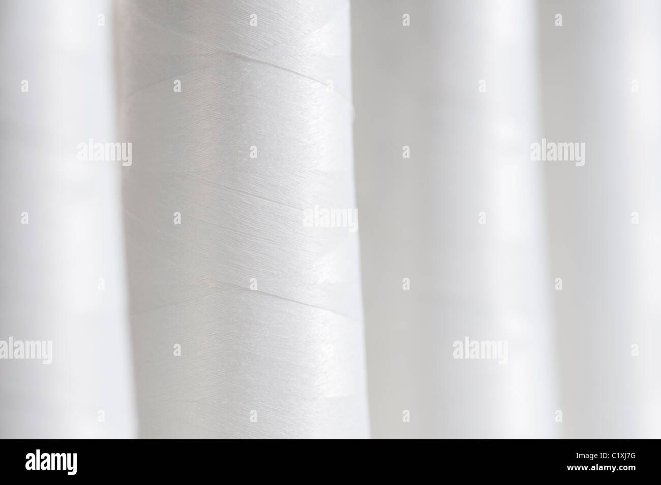 Serger with white thread spools Stock Photo - Alamy