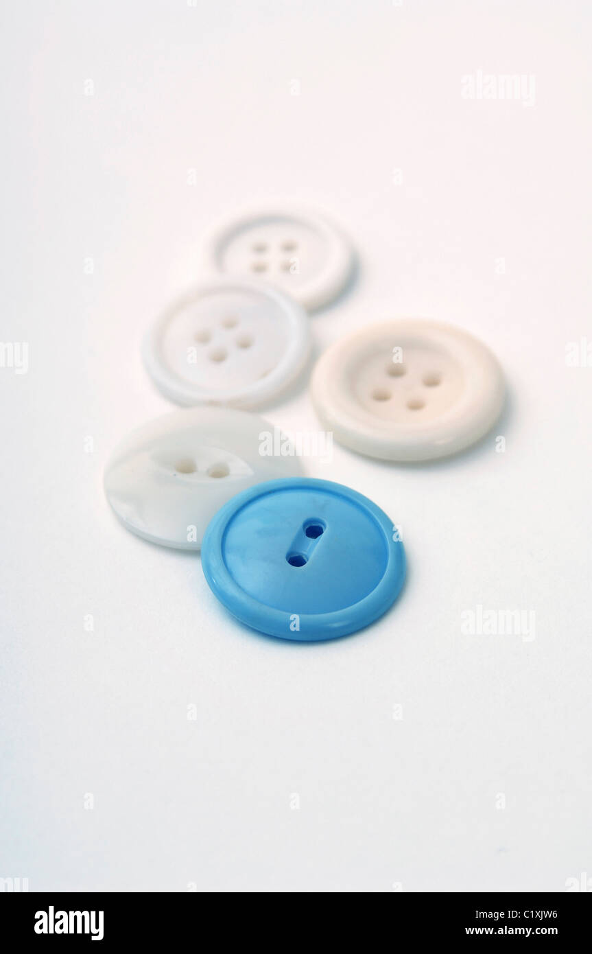 One blue button amongst various white buttons on a white background ...