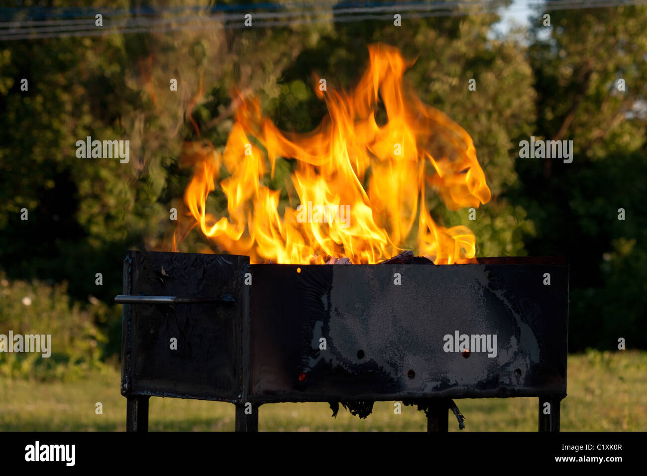Orange flames leaping over an open empty grill outdoors Stock Photo - Alamy