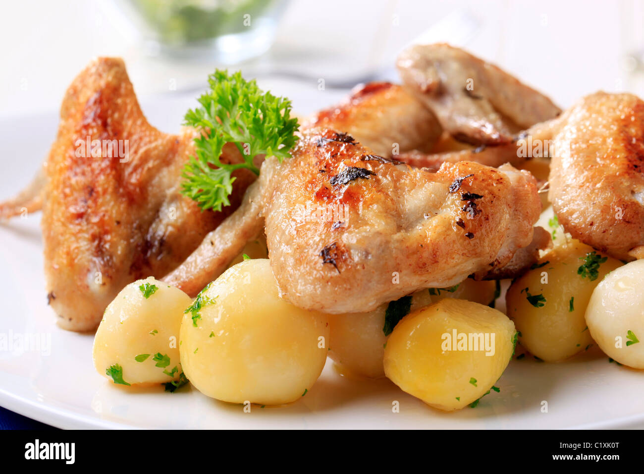 Roasted chicken wings and potatoes - closeup Stock Photo - Alamy