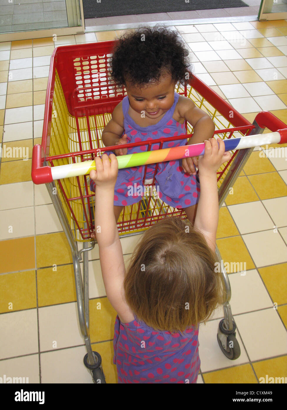 Two young children having fun with a shopping cart Stock Photo - Alamy