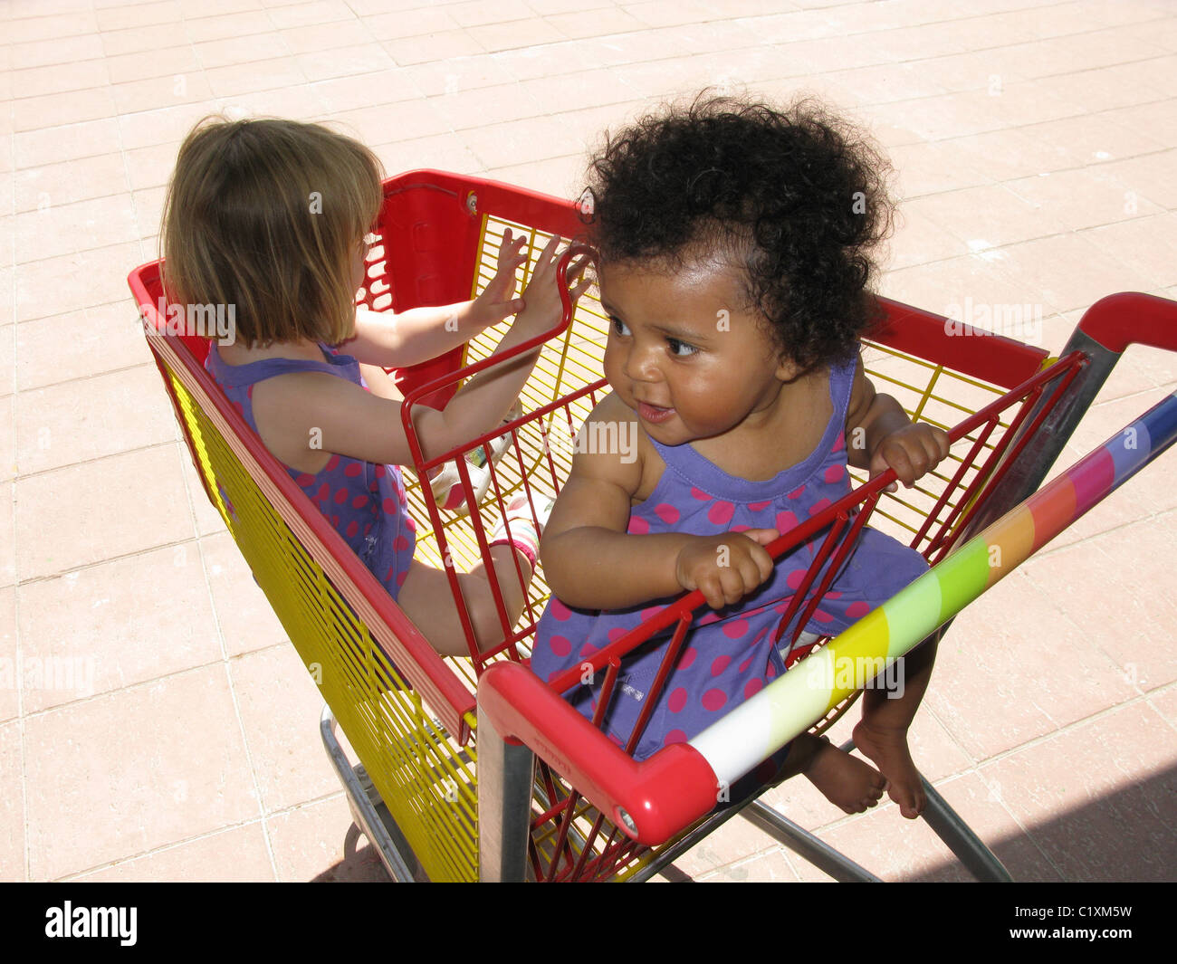 Two young children having fun with a shopping cart Stock Photo - Alamy