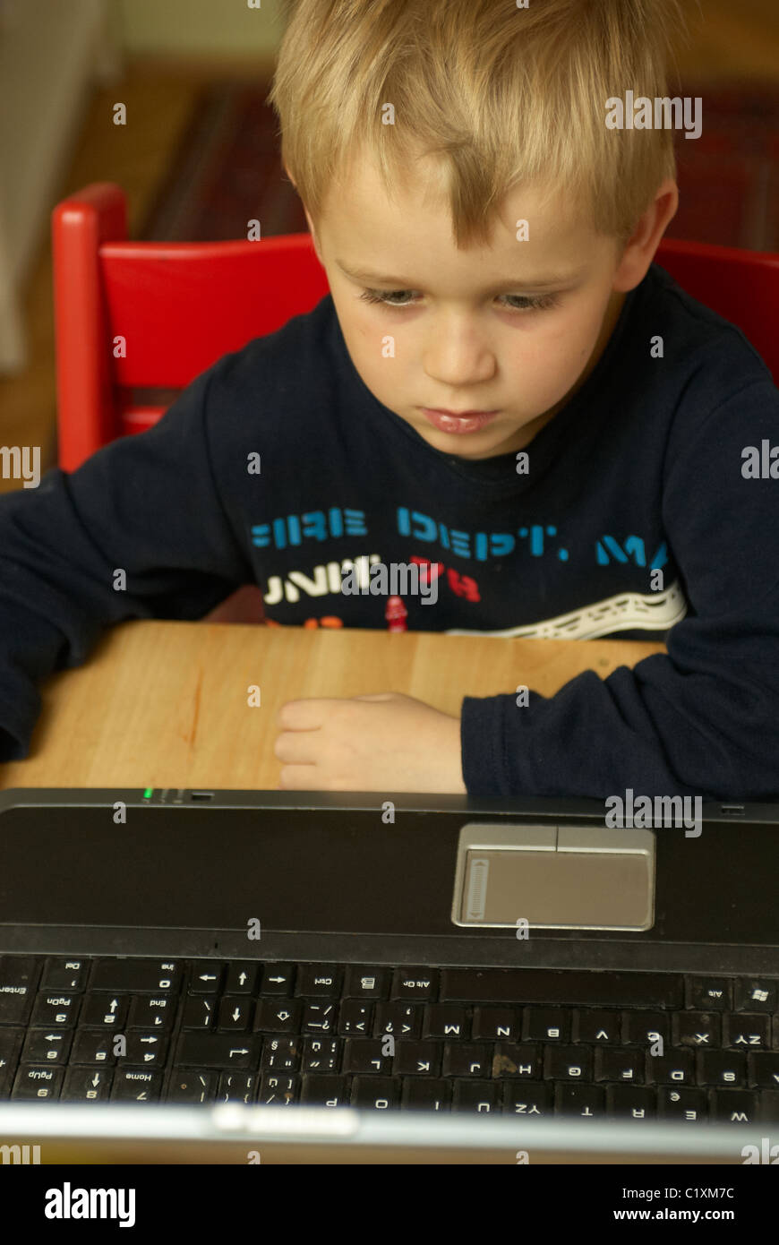 Child blond boy playing with notebook - computer Stock Photo - Alamy