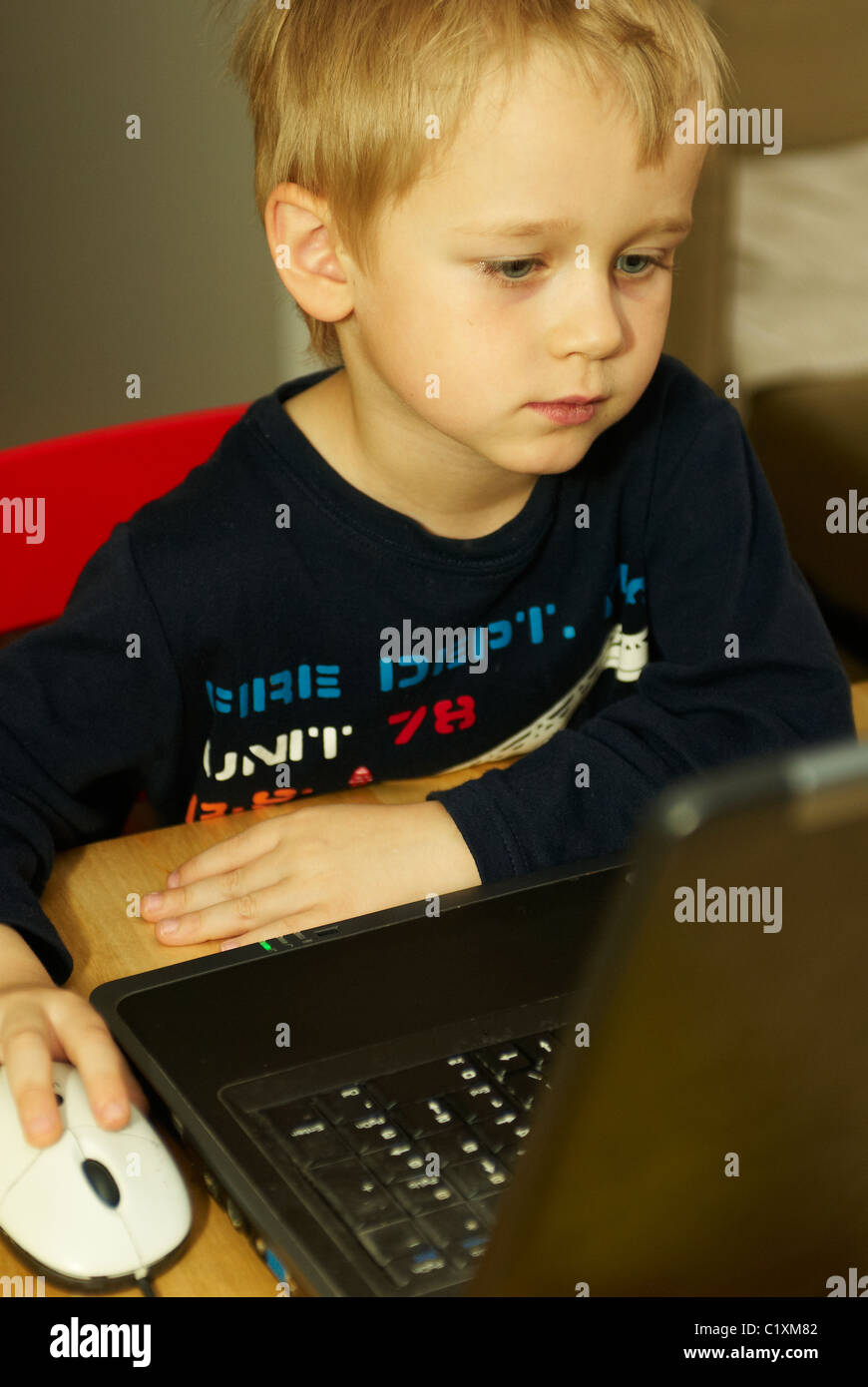 Child blond boy playing with notebook - computer Stock Photo - Alamy