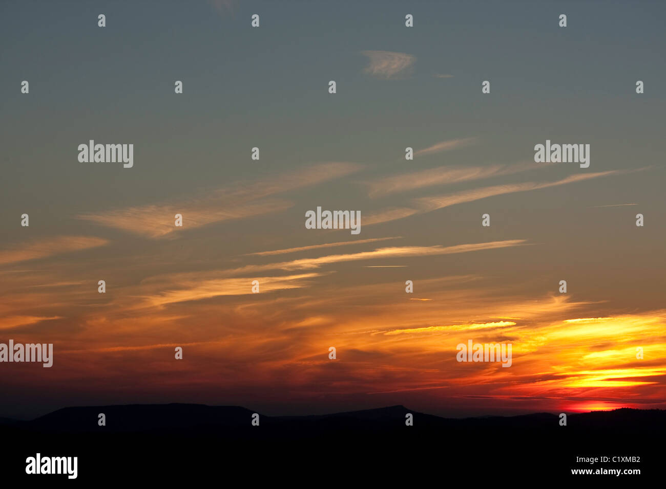 View of a red hot burning sun on the horizon over a cloudy sky Stock ...