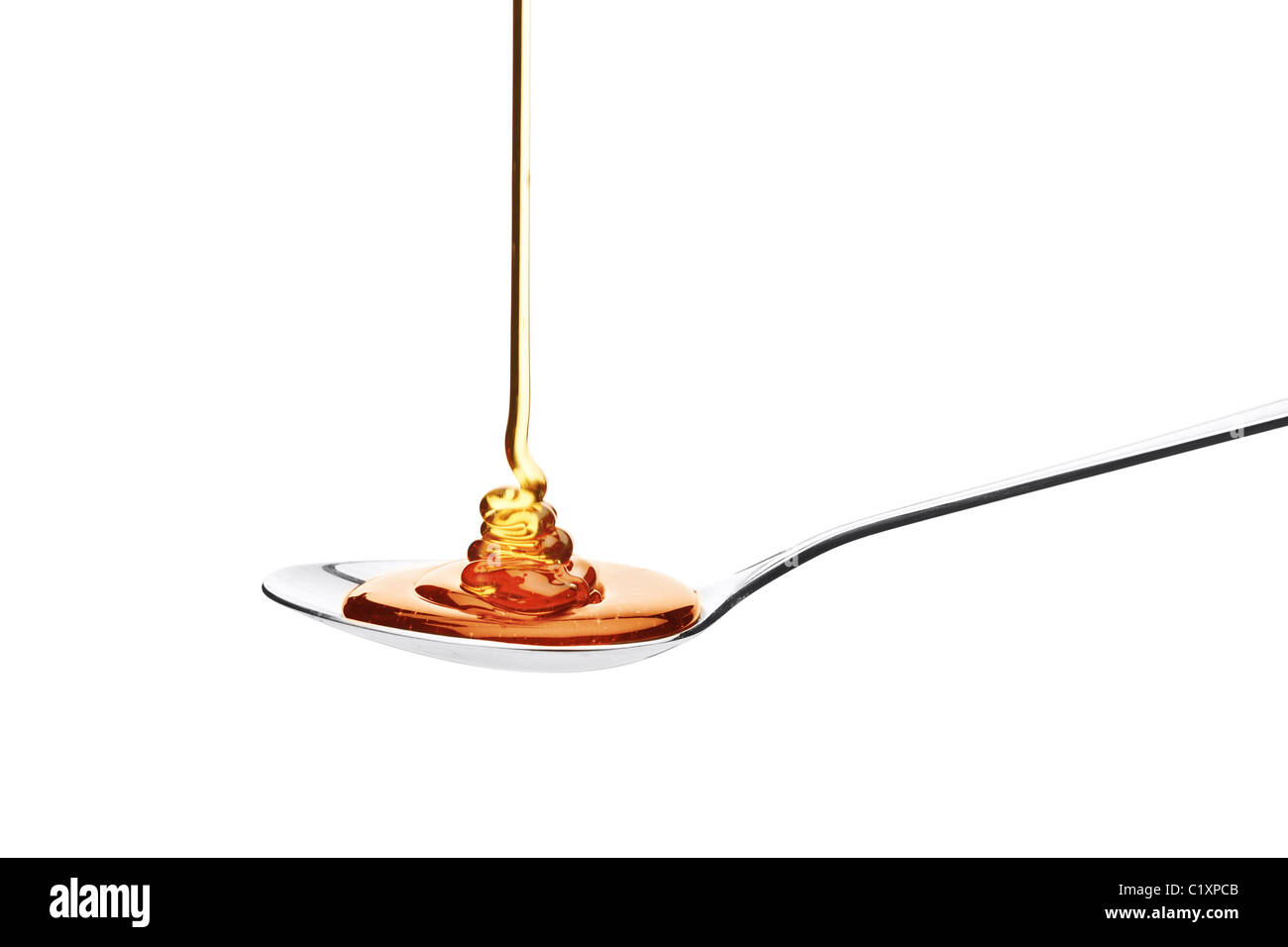 Honey falling on a spoon Stock Photo - Alamy