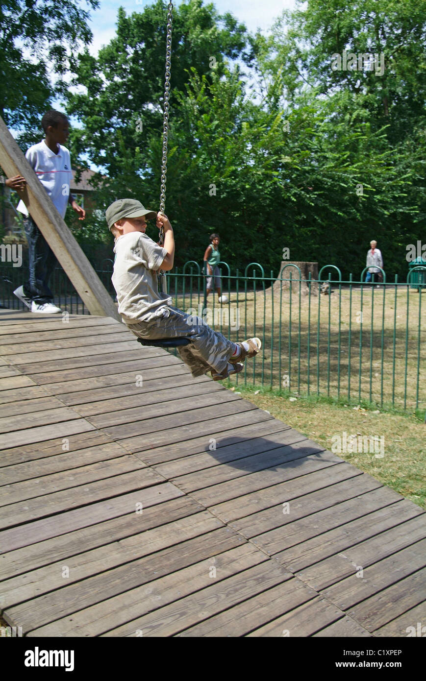 Boy at playing on swing Stock Photo - Alamy