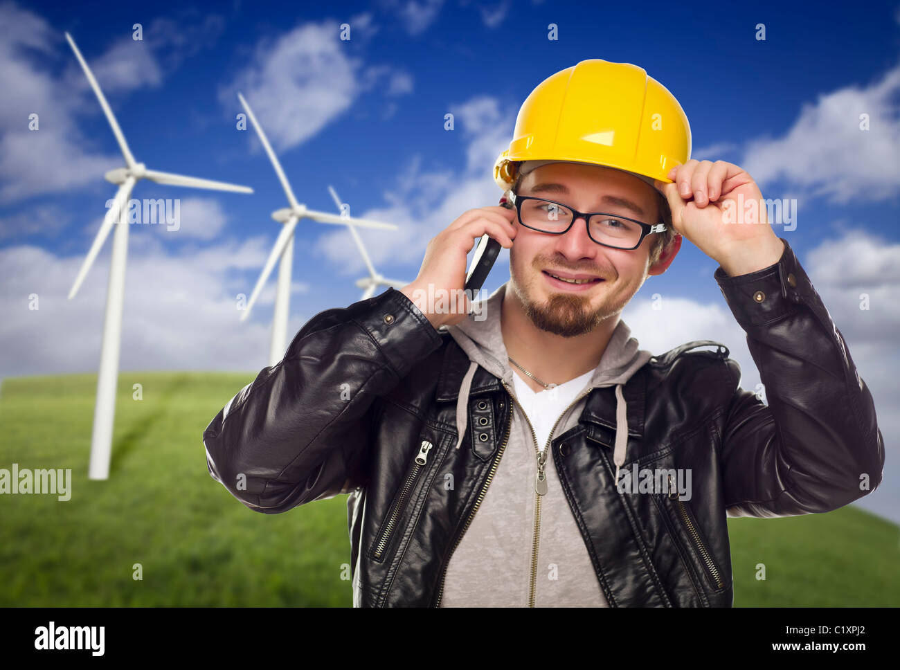 Hard Hat Wearing Engineer on Cell Phone with Wind Turbines Behind Him ...
