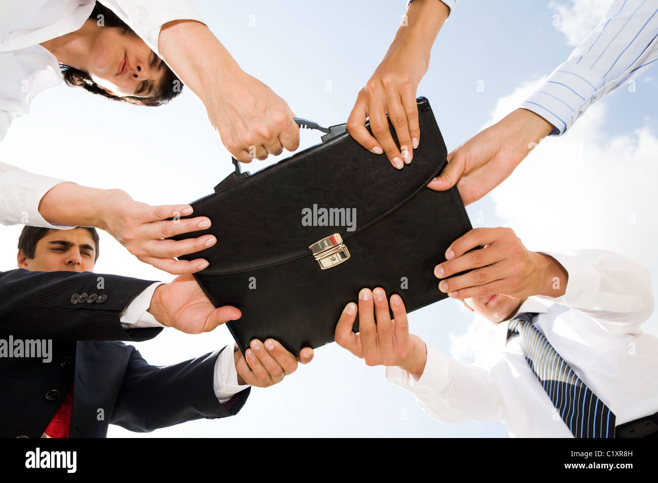 Below angle of people hands holding black leather briefcase ...