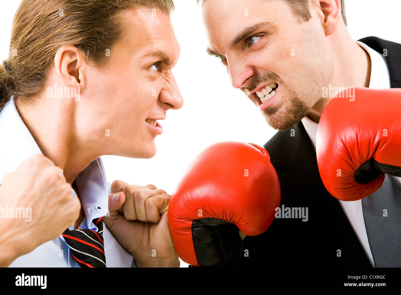 Portrait of aggressive businessmen in boxing gloves looking at each ...
