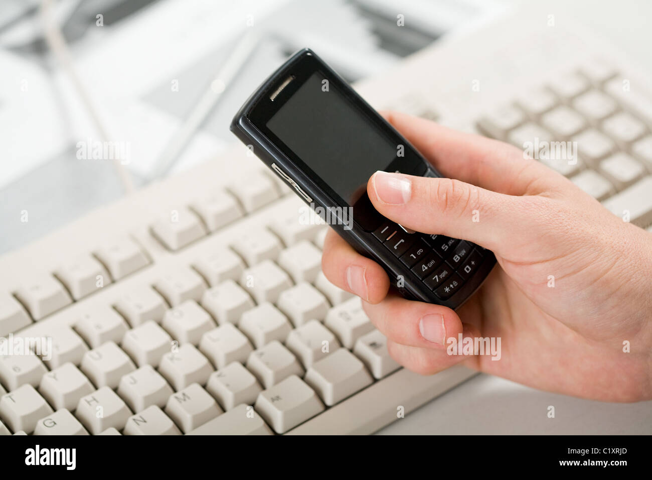 Photo of male hand holding cellular phone and pressing its buttons ...