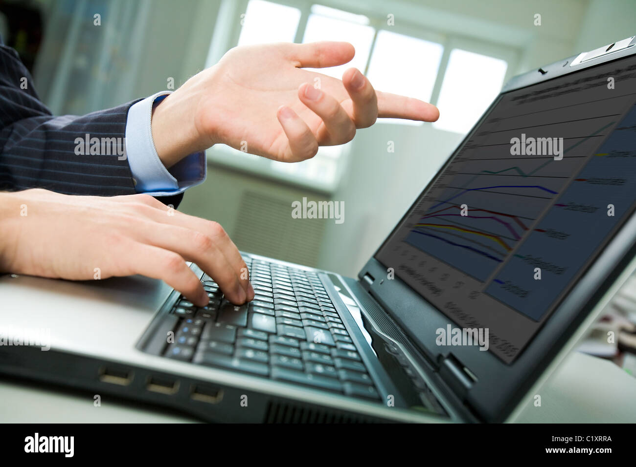 Close-up of male hand with forefinger pointing at laptop screen on ...
