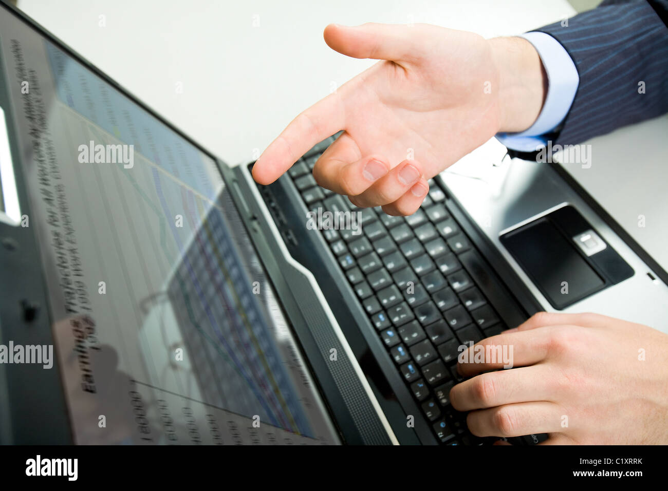 Above angle of male hand with forefinger pointing at laptop screen on ...