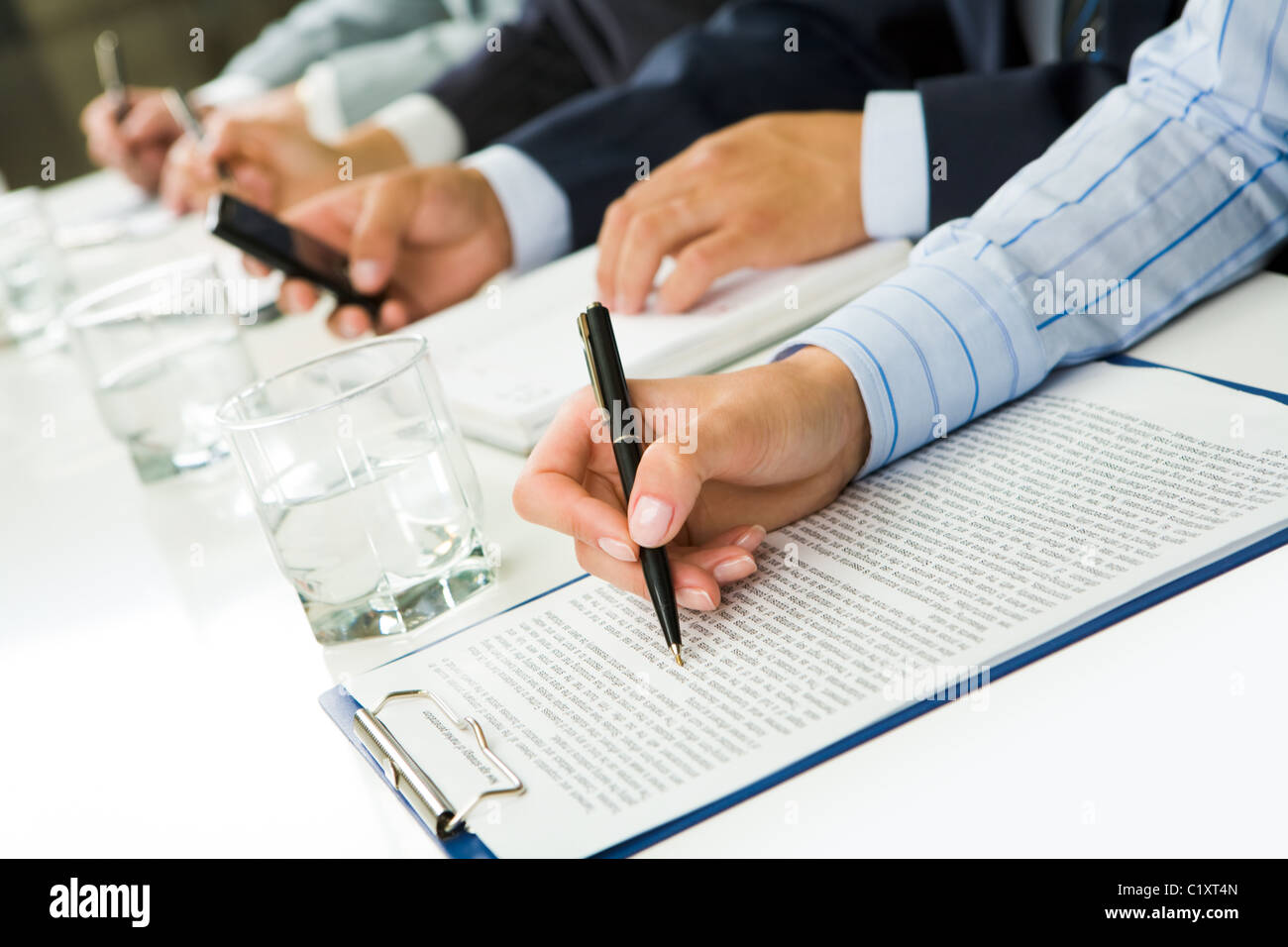 Image of human hand over paper during business seminar Stock Photo - Alamy