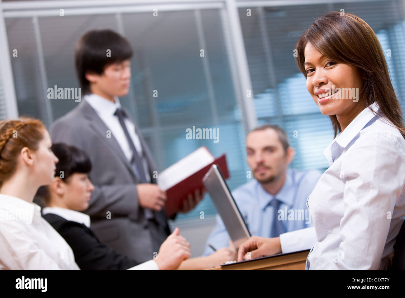 Portrait of smart employer looking at camera on background of people ...