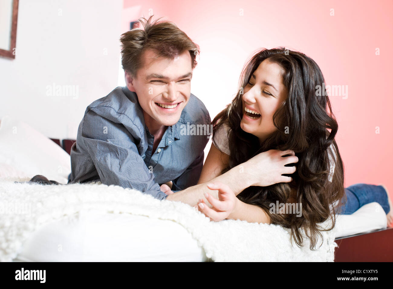 Couple laughing in bed Stock Photo - Alamy