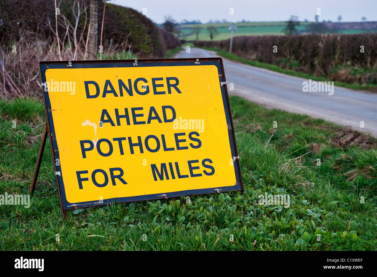 A road sign warning of pot holes Stock Photo - Alamy