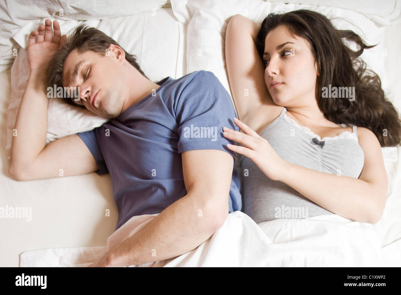 Woman waking up man Stock Photo - Alamy