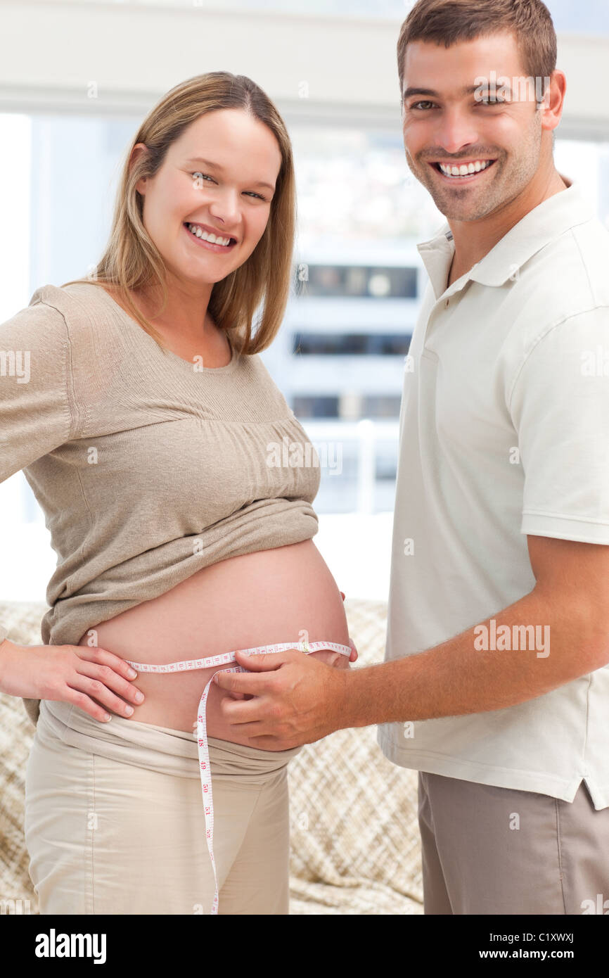 Adorable future parents with a measuring tape Stock Photo - Alamy