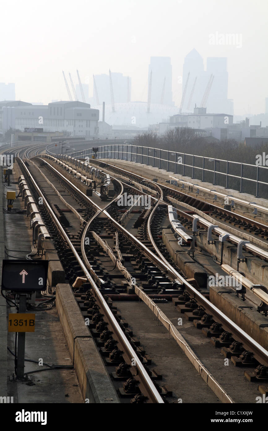 UK. DOCKLANDS LIGHT RAILWAY (DLR) TRAIN TRACKS WITH CANARY WHARF IN ...
