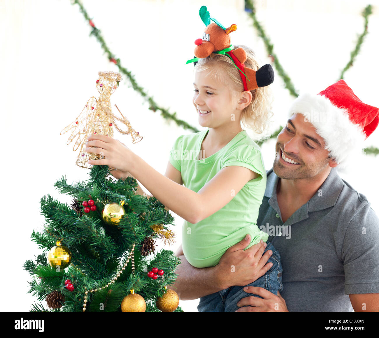 Cute little girl decorating the christmas tree with her father Stock ...