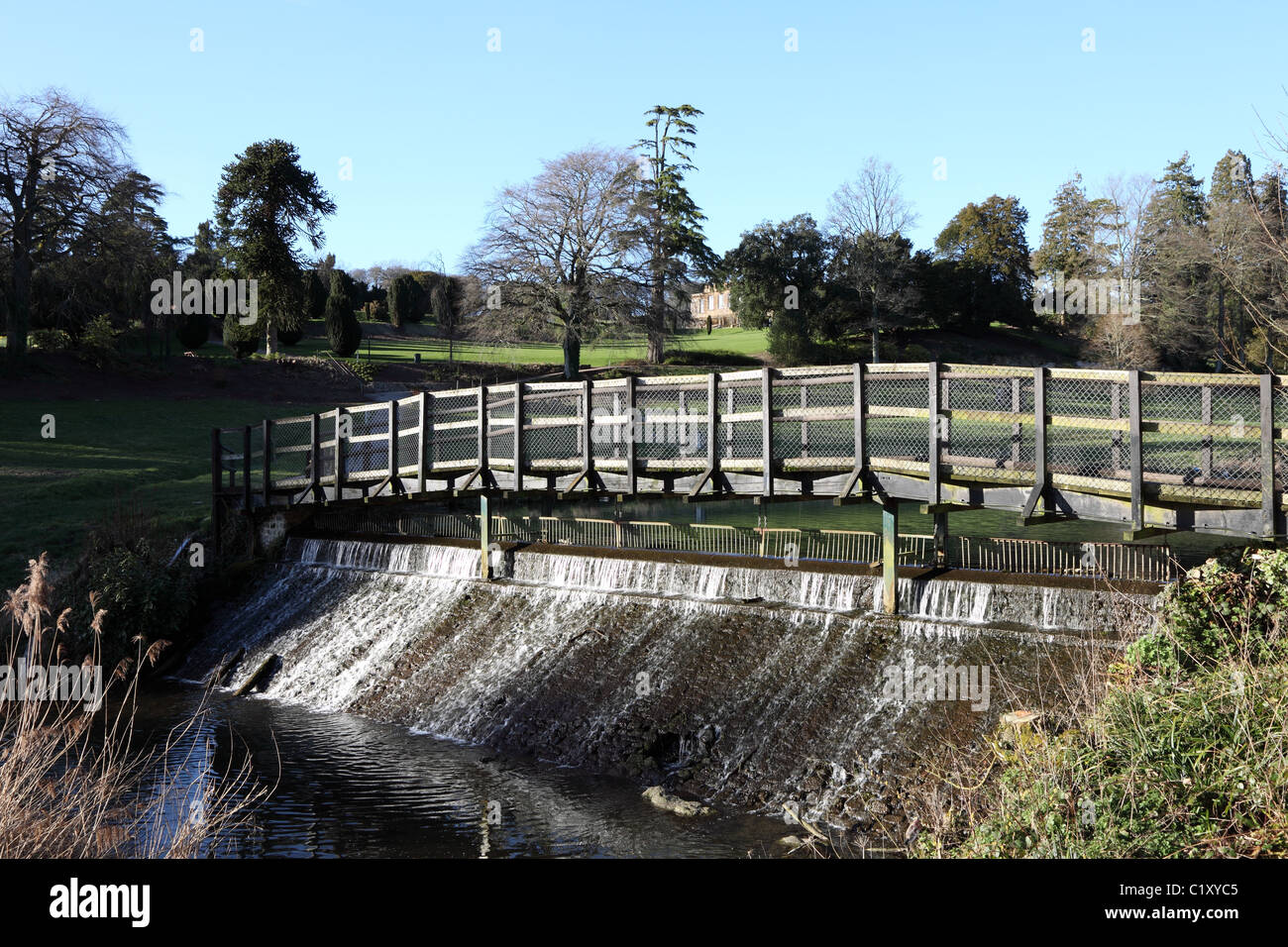 Bridge over weir at Cricket St Thomas Somerset Stock Photo - Alamy
