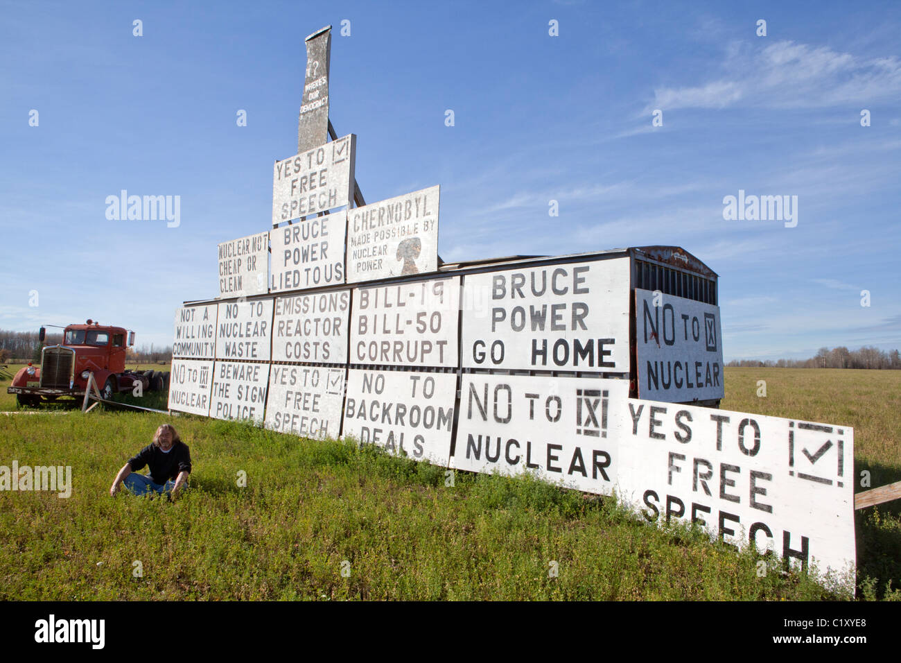 Male farmer in front of anti nuclear power plant protest billboards in ...