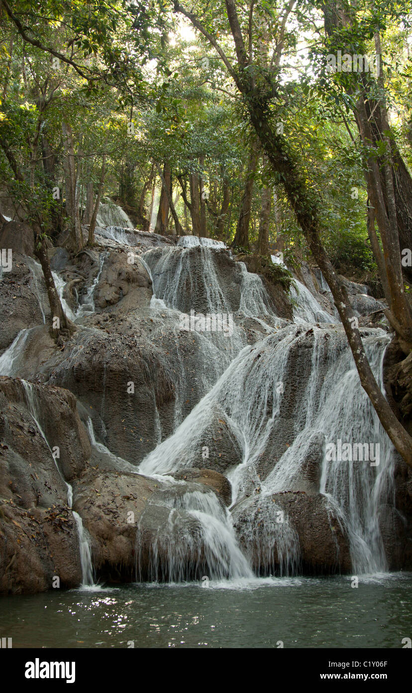 Waterfall in jungle in Thailand, sunshine entrenches through foliage ...