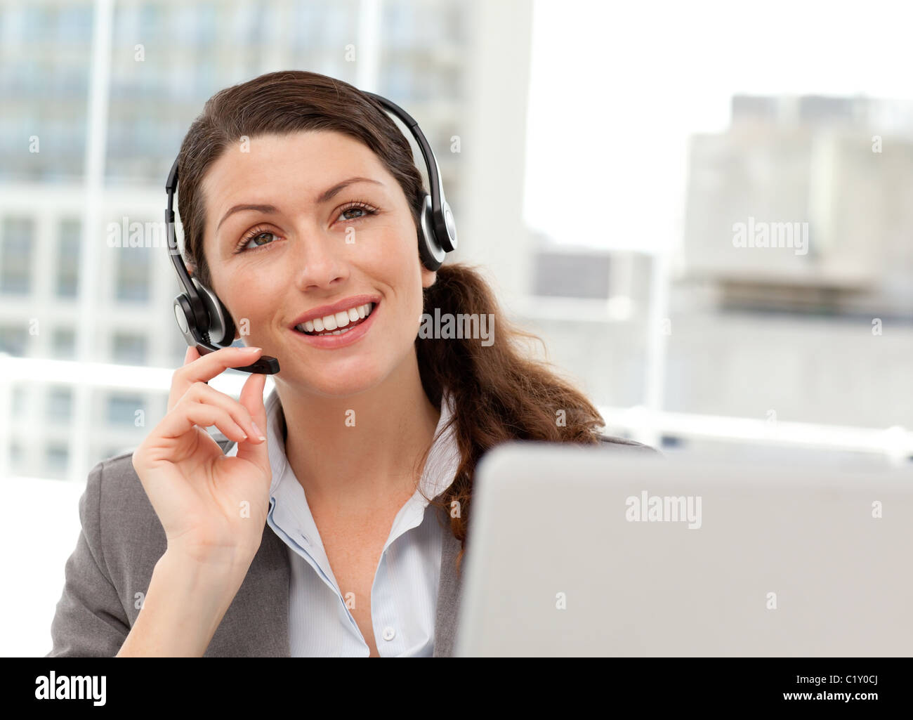 Thoughtful businesswoman talking on the phone while working on her ...