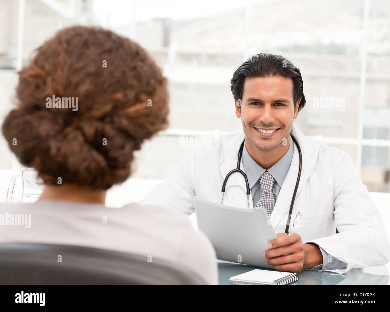 Cheerful hispanic doctor dring an appointment with a patient Stock ...